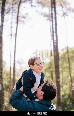 A man lifting his son up in his arms, playing outdoors Stock Photo - Alamy