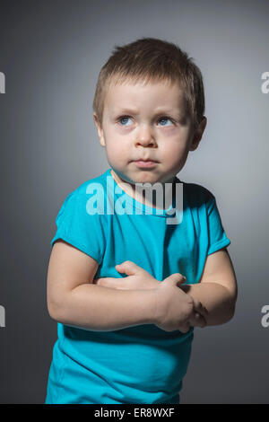 Angry boy looking away against gray background Stock Photo - Alamy