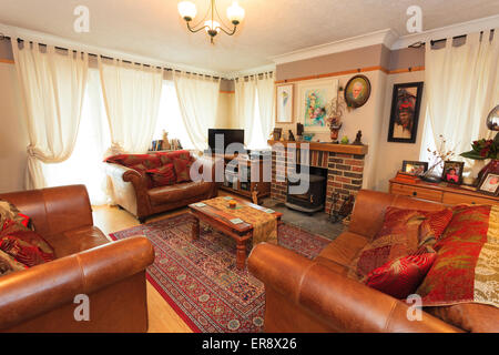 Lounge in english house with three leather sofas and wood burner Stock ...