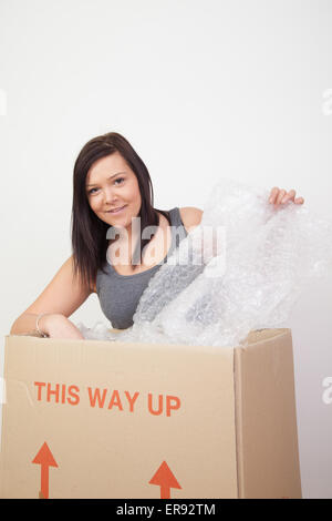 Woman preparing to pack / unpack a cardboard box to move house Stock ...