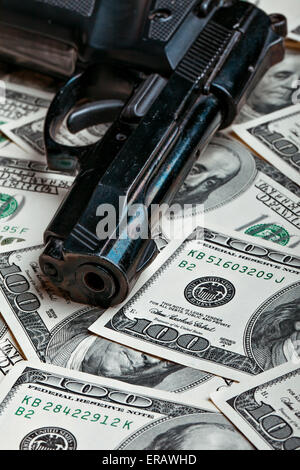Money and weapons. Gun against the dollar bills Stock Photo - Alamy