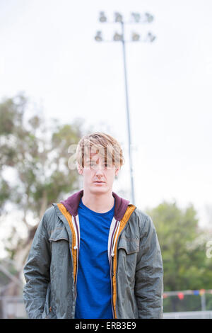 Handsome young redhead man in sunglasses, brushing hair with hand and ...