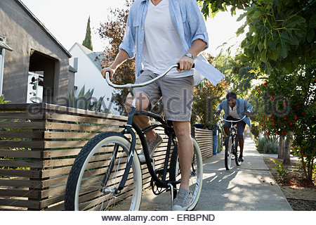 Group of friends riding bicycle outdoors. Man and women cycling in the ...