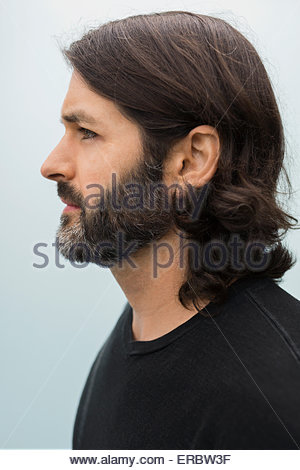 Profile portrait of a man with a long beard and a short haircut in ...