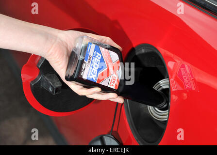 pouring fuel system cleaner into the tank of a car Stock Photo - Alamy