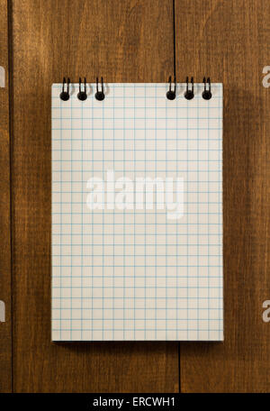 checked notebook on wooden background Stock Photo - Alamy