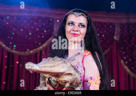 Young woman circus act holding python snakes Stock Photo - Alamy