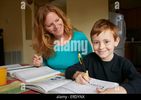 Happy mother helping his son for homework against bright blue sky over ...