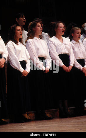 Choir of school girls singing wearing red uniform sweaters, white ...