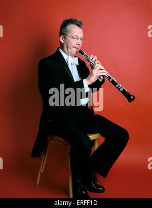 Man playing oboe against red background. Close-up. Side view Stock ...