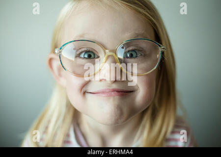 Funny and playful girl making goofy faces, squinting folding lips and ...
