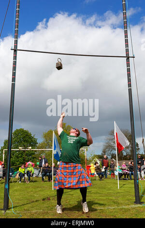 Man throwing the weight over the bar, a traditional style of game ...