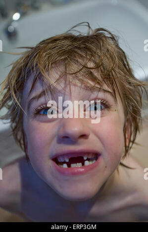 A boy with wet hair and gappy teeth smiles at the camera Stock Photo ...