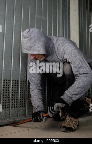 MODEL RELEASED. Man breaking into building Stock Photo - Alamy