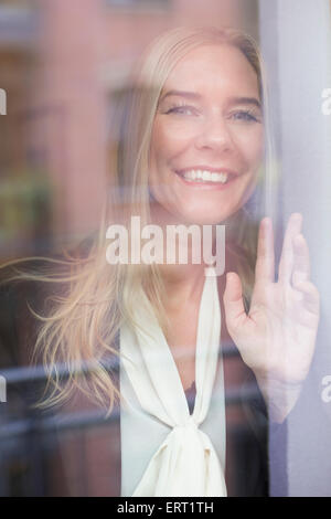 Businesswoman waving out window Stock Photo - Alamy