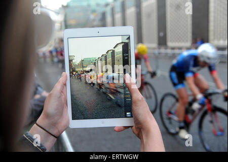 Spectator photographing the elite mens cycling race at Smithfield ...