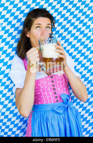 Beautiful Oktoberfest woman in a traditional Bavarian dirndl serves ...
