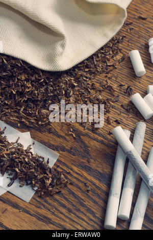 Rolling cigarettes with filters papers and plenty finely cut tobacco ...