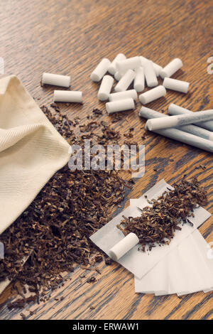 Rolling cigarettes with filters papers and plenty finely cut tobacco ...