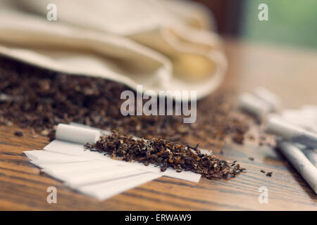 Rolling cigarettes with filters papers and plenty finely cut tobacco ...
