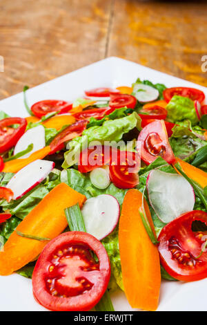 Slices of carrot, spring onion, radish on the plate. photo top view ...