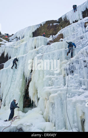 Ice climber climbing a frozen waterfall Kinder Downfall on Kinder Scout ...