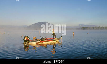 A largemouth bass fisherman on Crane Prairie Reservoir on a foggy ...