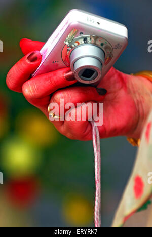 Hand woman holding the camera Background of trees and flowers Stock ...