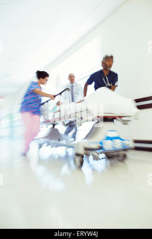 Doctors rushing patient on stretcher down hospital corridor Stock Photo ...