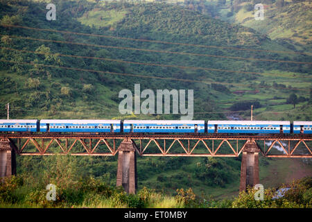 Indian Railways train passing by heightened up bridge at Igatpuri near ...