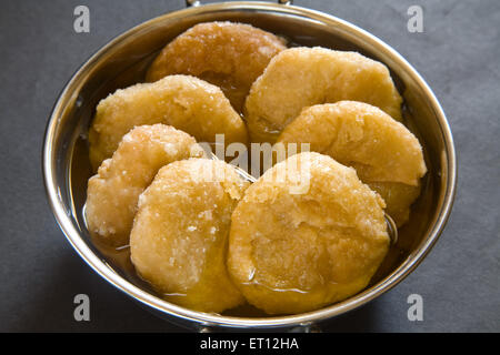 Indian sweet ghari ghaari dipping in sugar syrup in steel kadahi on ...