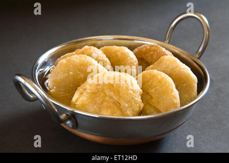 Indian sweet ghari ghaari dipping in sugar syrup in steel kadai on ...