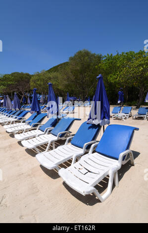 Wooden deck chairs and umbrellas near infinity pool in luxury resort ...