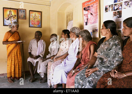 Female rural health worker teaching villagers about improved hygiene ...