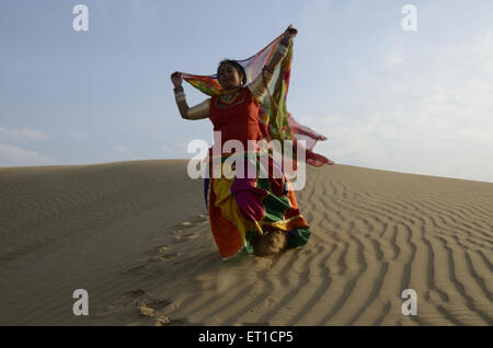 Rajasthani woman running down of Sand Dune Jaisalmer Rajasthan India MR ...
