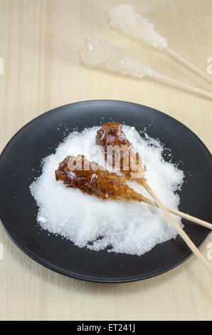 plate with unrefined brown cane sugar on gray wooden background. top ...