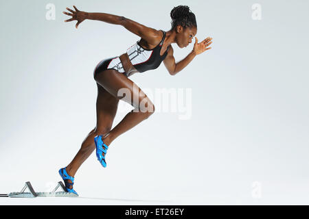 Female runner leaving the starting block in a relay race Stock Photo ...