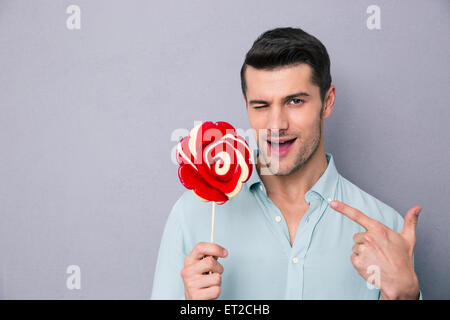 Confident adult man winking, pointing finger at you and winking ...