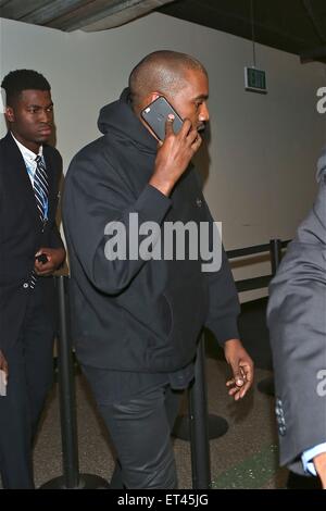 Kanye West talking on his cellphone as he leaves on a flight from Los ...