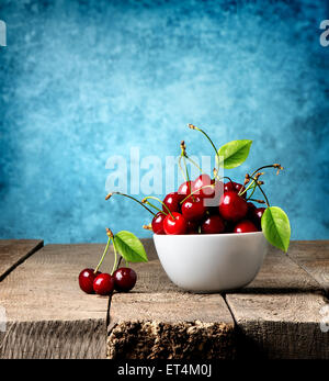 Ripe red cherries in a plate on a white table, close up Stock Photo - Alamy