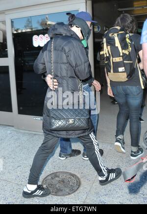 Katy Perry arrives at LAX hiding behind her bodyguard and an airline ...