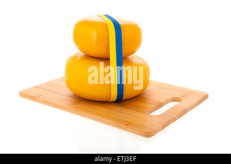 Two stacked whole Swedish cheeses isolated over white background Stock ...