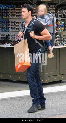 The Bold and the Beautiful soap actor, Adam Gregory carries his son, Kannon in a back carrier ...