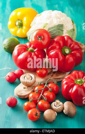 Red pepper, tomato, red radish on a dark wooden table on a black ...
