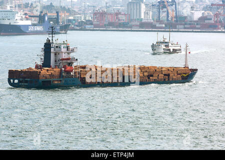 A cargo vessel fully laden with containers passing under the Ponte 25 ...
