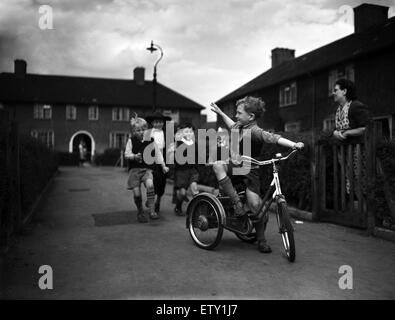 Boys playing on a council estate as one of their mothers looks on ...