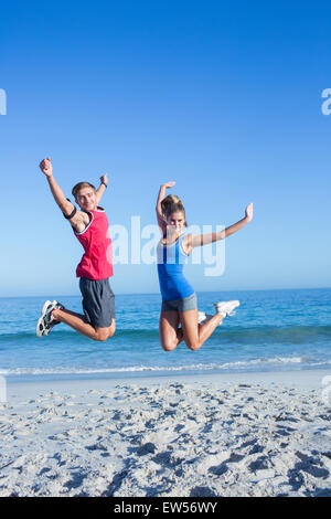 Happy young couple jumping Stock Photo - Alamy