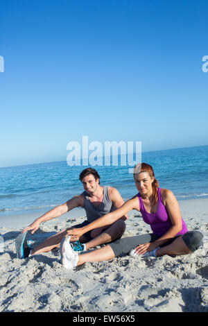 Happy couple stretching together beside the water Stock Photo - Alamy