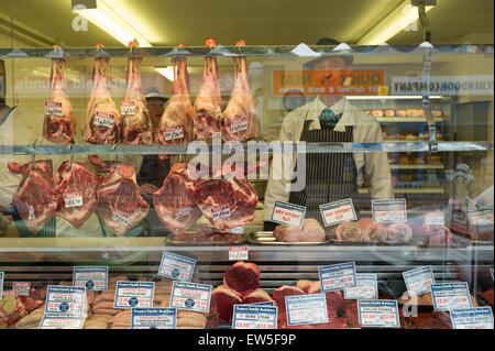 Looking through a butchers shop window with various types of meat for ...