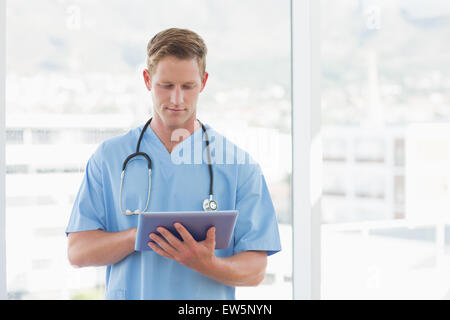 Doctor writing on clipboard beside windows Stock Photo - Alamy